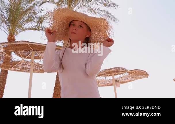 Low angle shot of a young girl with braids wearing a white tunic and ...