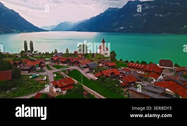 Aerial view of traditional Swiss houses rooftops on the shore of a lake ...