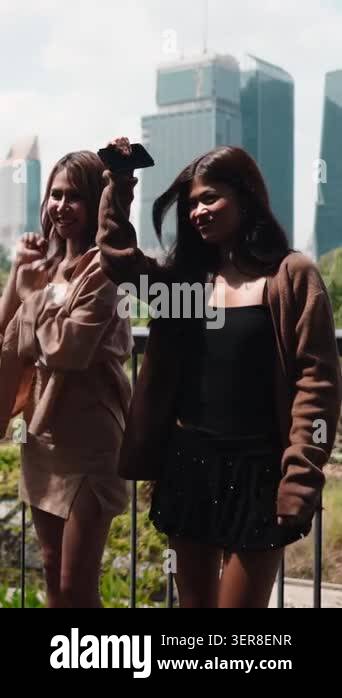 Two happy young women dancing together, recording a video for social ...