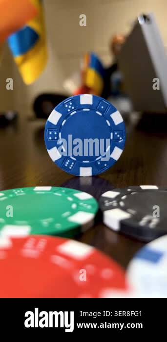 Colorful poker chips on casino table with blurred background lights ...