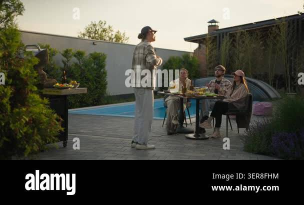 A relaxed residential backyard scene with one person standing in the ...