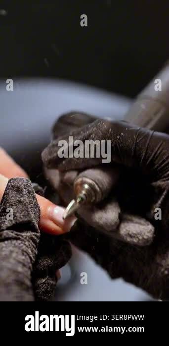 Macro close-up of nail technician removing old gel polish with electric ...