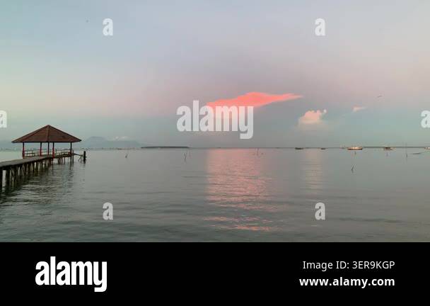 4K sunset seascape with a pier and moored fishing boats at Tanjung ...