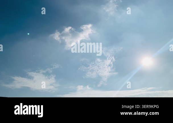 Bright sun with lens flare and wispy clouds over Jakarta, Indonesia ...