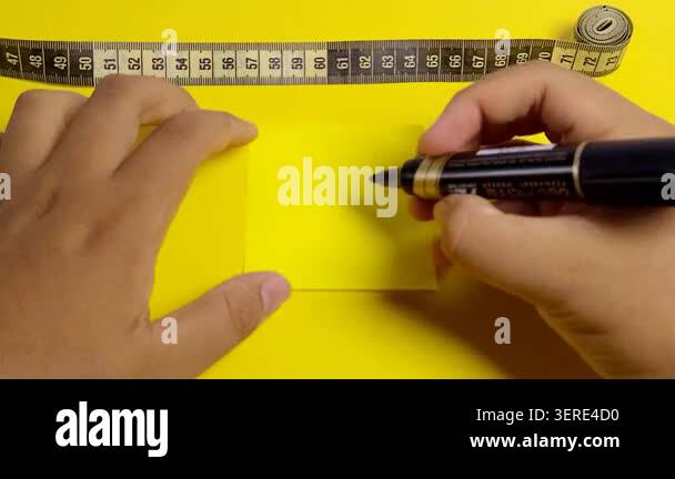 A person writing weight reduction targets on a note while a measuring ...
