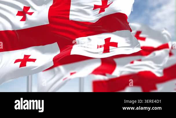 National flags of Georgia waving in the wind on a clear day. White with ...