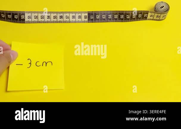 Weight loss milestones written on sticky notes with a tape measure in ...