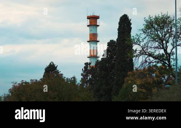 A tall communications tower painted in horizontal orange and white ...