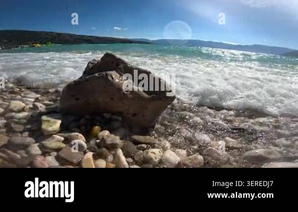 Rock on pebble beach with waves and bright summer sea croatia krk Stock ...