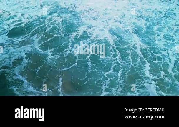 Low aerial drone footage flying close above breaking ocean waves along ...
