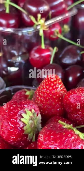 Sweet strawberries dark cherries and ripe apricots displayed in clear ...