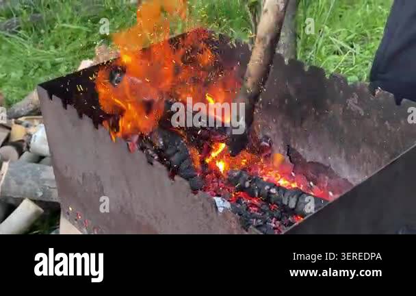 Glowing embers and burning firewood mixed with wooden stick inside ...