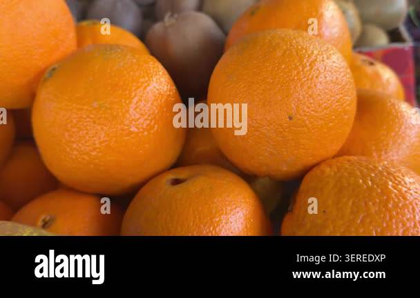 Juicy oranges and ripe kiwi fruits arranged together on market counter ...