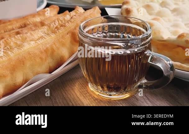 Traditional South Asian breakfast featuring hot tea served in a glass ...