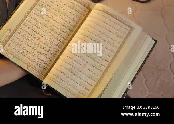 Muslim reading the Holy Quran in warm ambient lighting during a moment ...