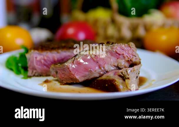 Chef in black gloves seasons, sears and bastes a ribeye steak with ...