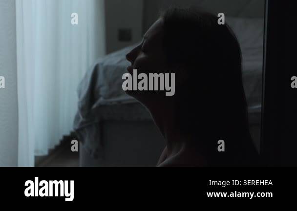 Woman in emotional distress covering face with hands at home ...