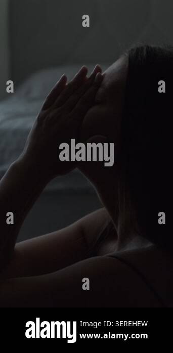Woman in emotional distress covering face with hands at home ...