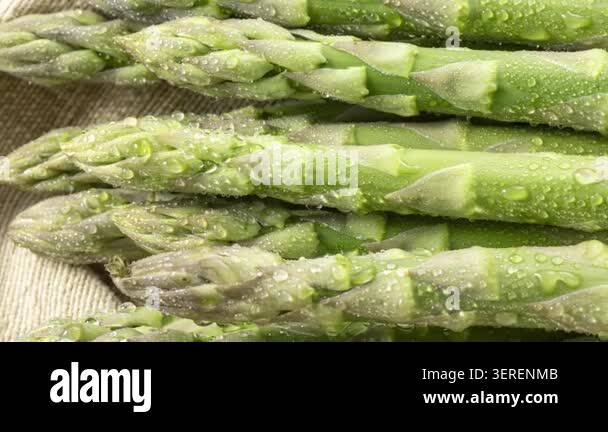 Fresh green asparagus spears with water drops arranged on white ...