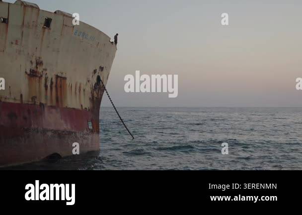 Tourist diving from rusty old shipwreck near the coastline during ...