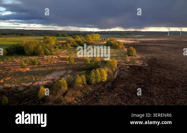 Drone footage flying over rural parkland, trees, fields, and a small ...