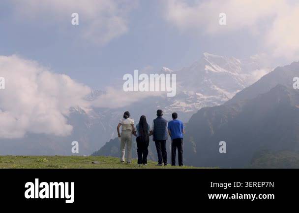 Four hikers stand on a green hilltop overlooking the breathtaking ...