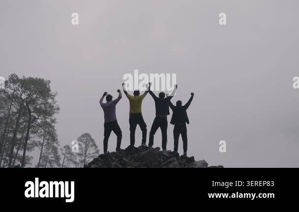 Four friends reach the summit of a mountain in the Garhwal Himalayas ...