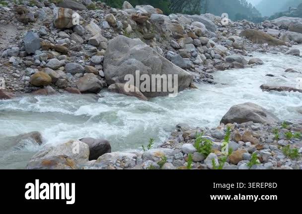 Scenic mountain river with turbulent water flowing over rocks ...