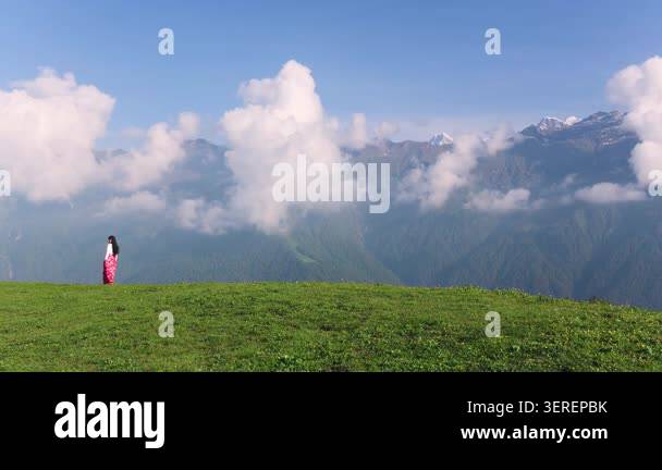 A lone trekker admires the breathtaking mist-covered Chaukhamba massif ...