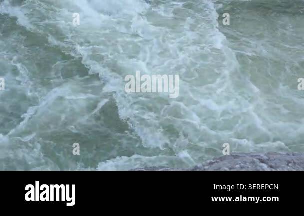 Dramatic close-up of a large breaking sea wave creating white foam and ...