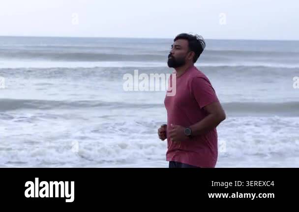 Bearded Man Jogging on Beach with Yellow Water Bottle for Summer ...