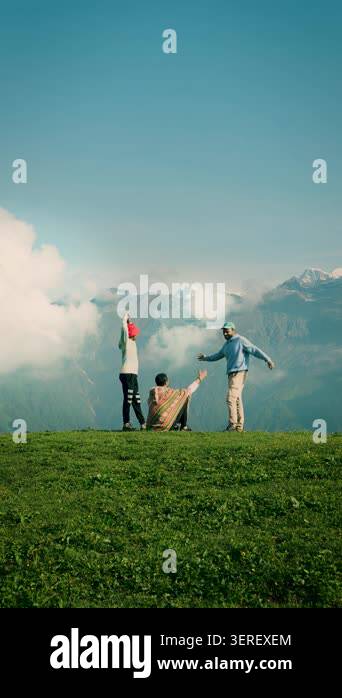 Group of hikers rejoicing on a misty mountain peak in Garhwal Himalaya ...