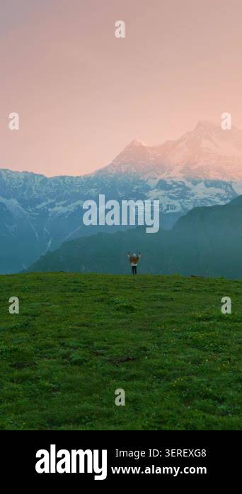 A lone hiker enjoys the breathtaking sunrise over the Garhwal Himalaya ...