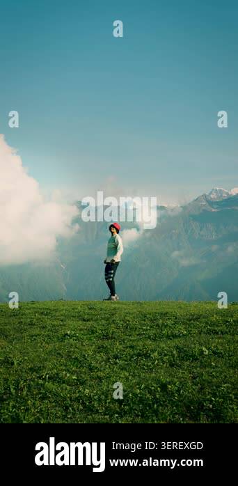 Adventurous female trekker explores scenic mist-covered peaks in the ...