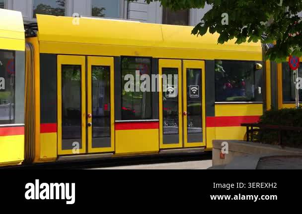 Basel, Switzerland, May 24, 2026: Yellow tram with red stripe stops at ...