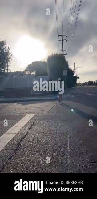 POV video of a jogger running along a suburban sidewalk in natural ...