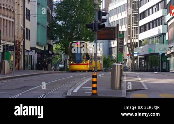 Basel, Switzerland, May 24, 2026: Yellow tram moves towards a stop in a ...