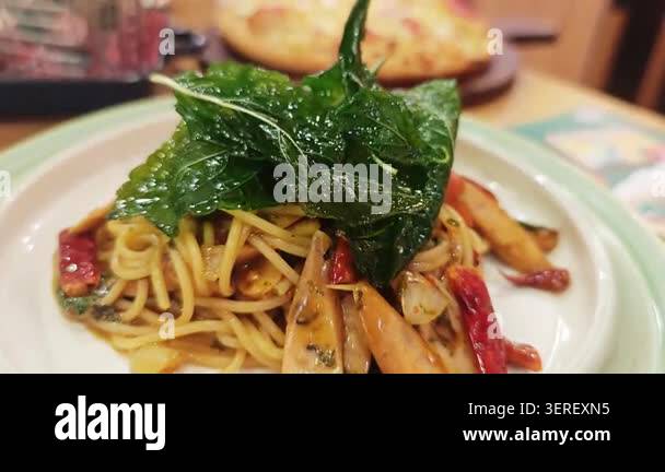 Spicy Thai fusion spaghetti with deep fried basil leaves Stock Video ...