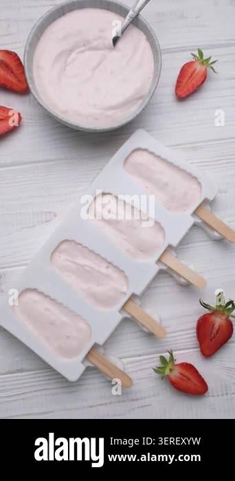 Preparing homemade strawberry popsicles for freezing Stock Video ...