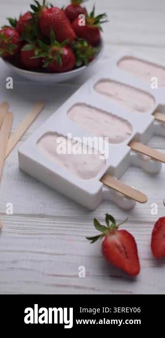 Preparing homemade strawberry popsicles for freezing Stock Video ...