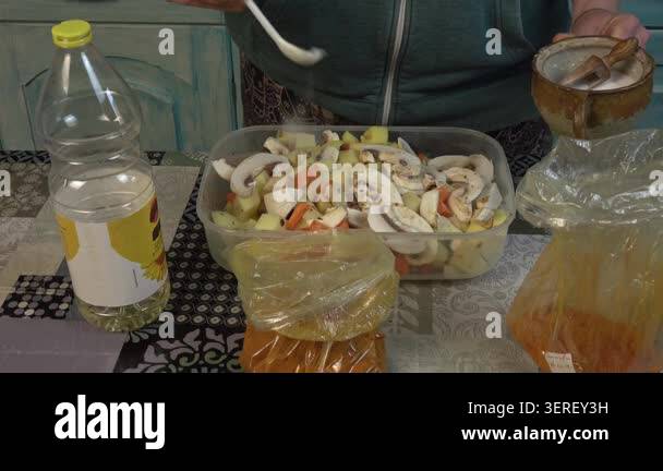 woman in the kitchen seasoning ingredients for tajine food with ...