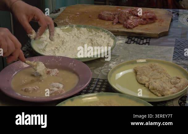 woman in the kitchen preparing chicken schnitzels - chicken meat coated ...