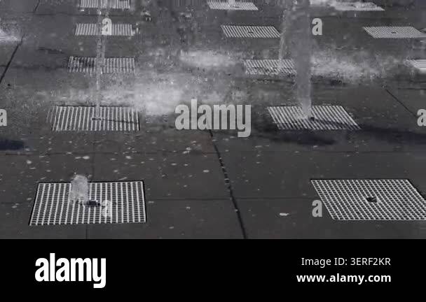 Water fountains create splashes and sprays in a public square ...