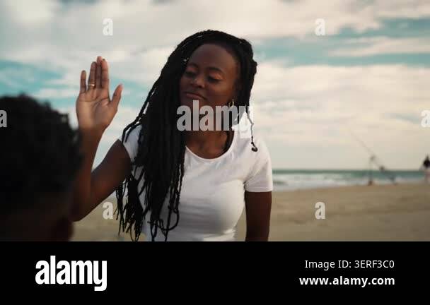 african american woman with curly hair, smiling, laughing at the beach ...