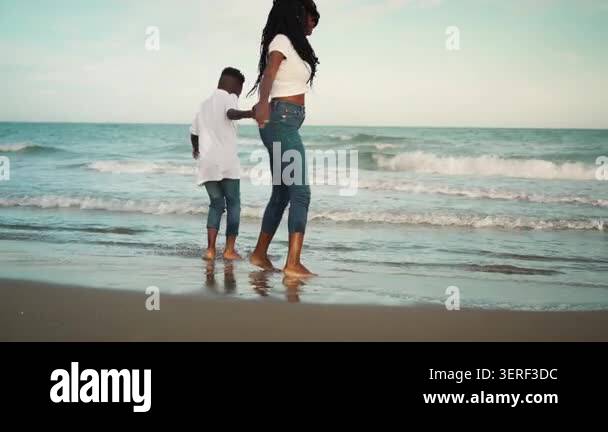 happy family on beach. mother and daughter walking on the seashore ...