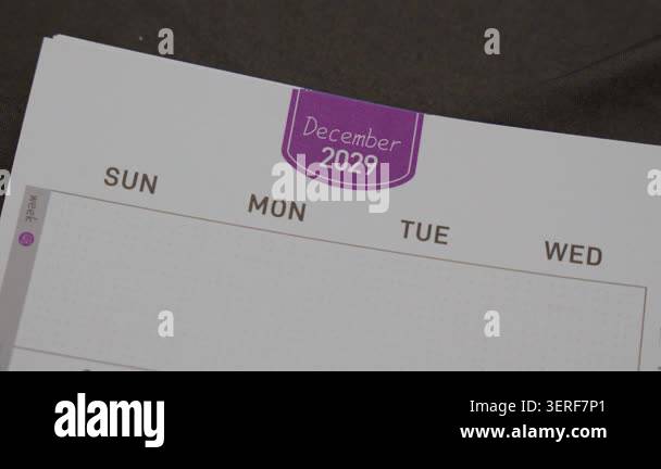 finger pointing at December 2029 planner page close up for scheduling ...