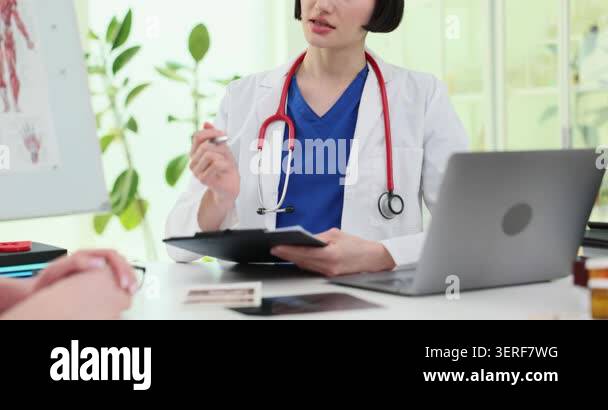 Woman doctor holds clipboard while consulting patient. Specialist ...