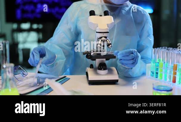 Experienced researcher places drop of transparent liquid with pipet ...