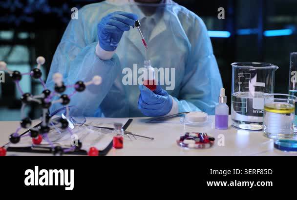 Lab worker analyzes texture and deep bright red color of liquid in ...