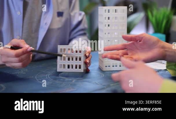Women architect designers discuss construction with plastic models and ...